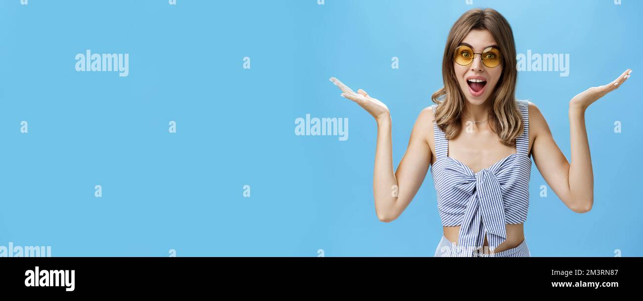 Waist-up shot of charismatic cute young woman in sunglasses raising ...