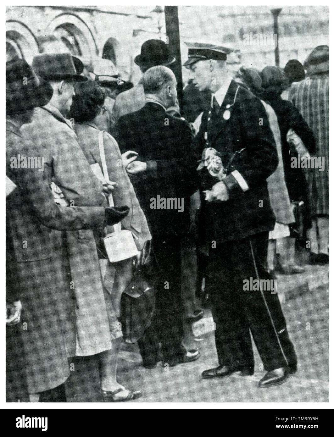 Bus conductor collecting fares from queuers, September 1939 Stock Photo ...