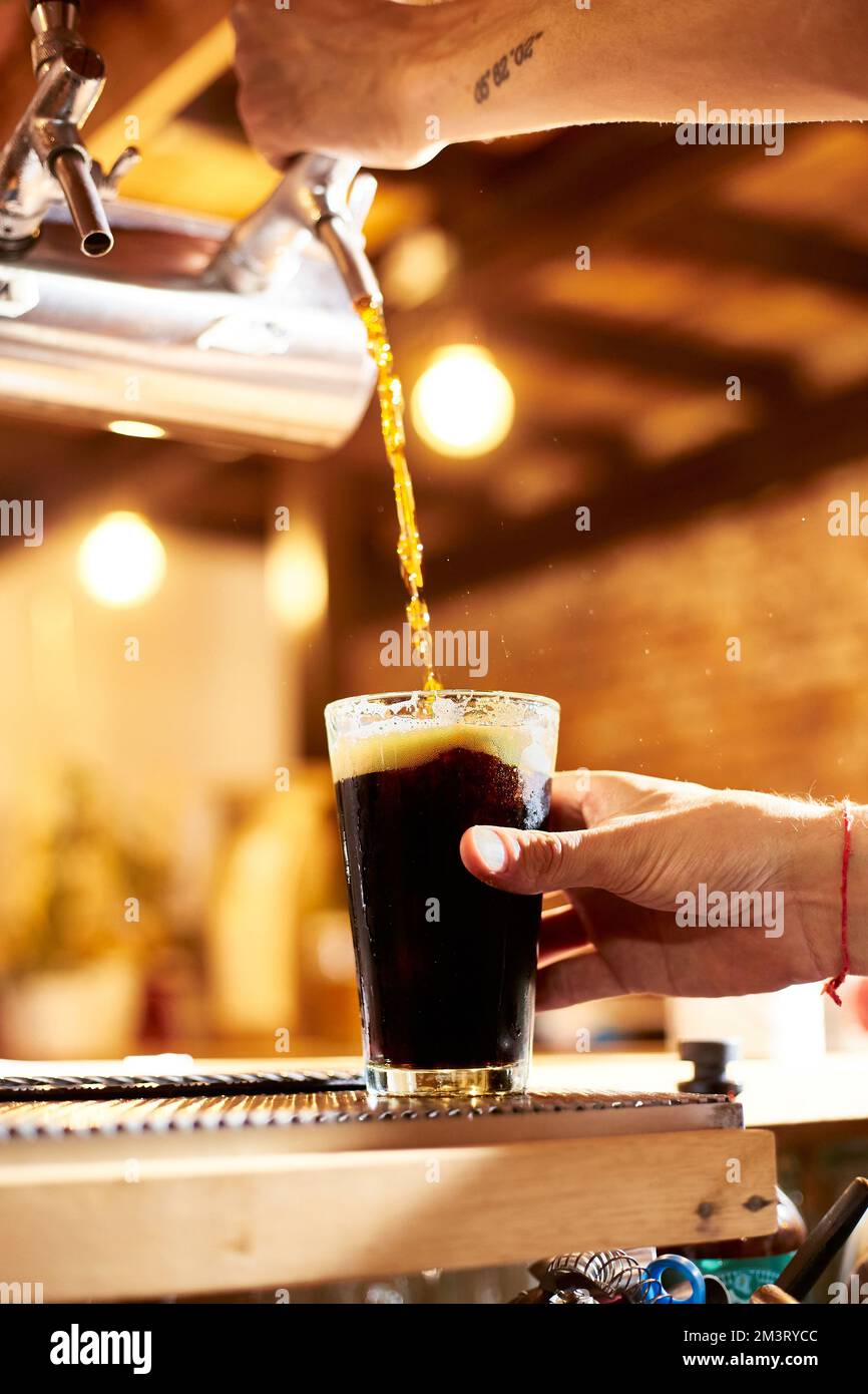 Hand pouring beer in glass hi-res stock photography and images - Alamy