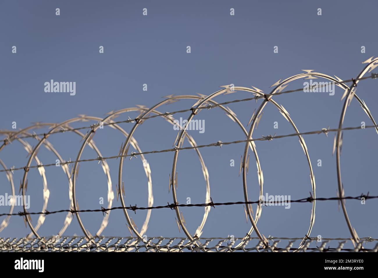 highly protected prison wall with barbed wire fence. steel grating ...