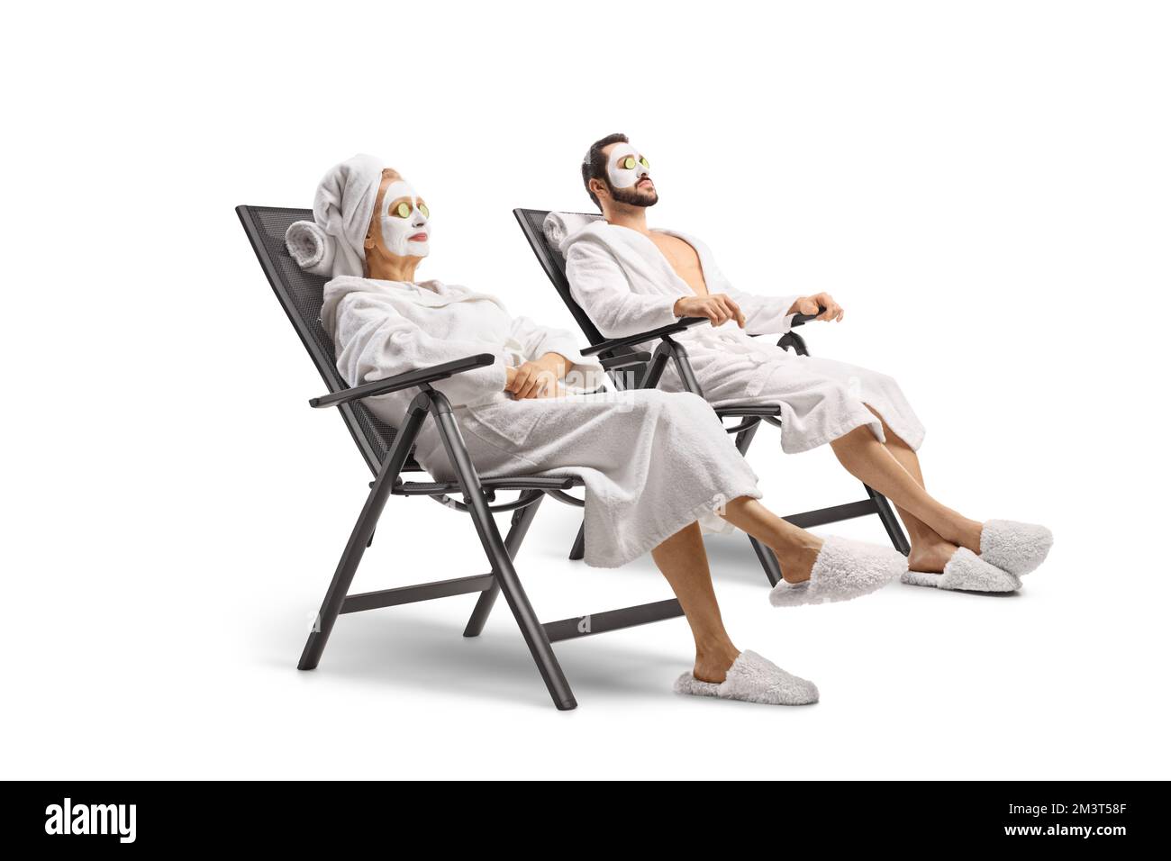 Man and woman in white bathrobes with face masks relaxing on chairs ...