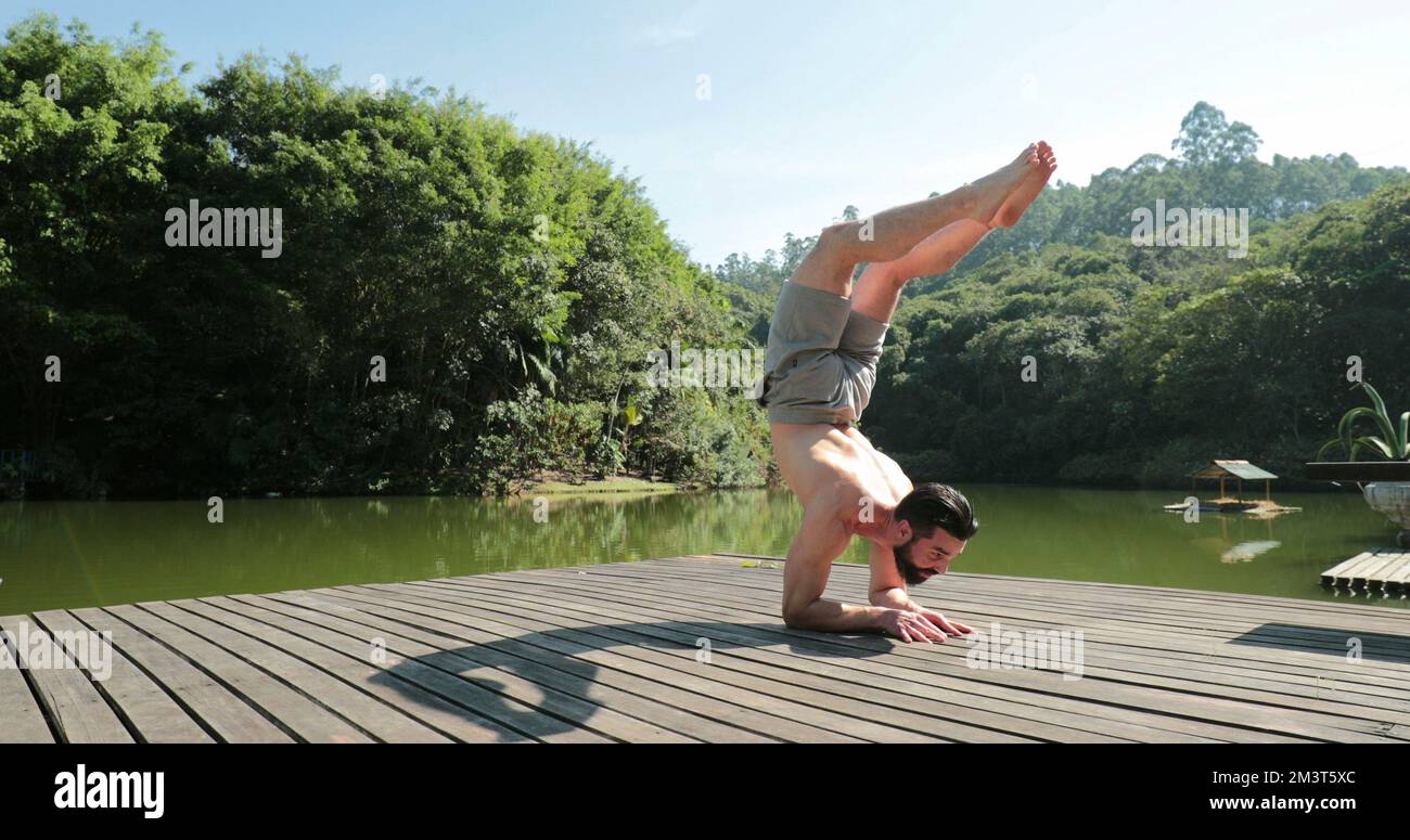 Person practicing Yoga outdoors in nature. Young man doing a hand-stand ...