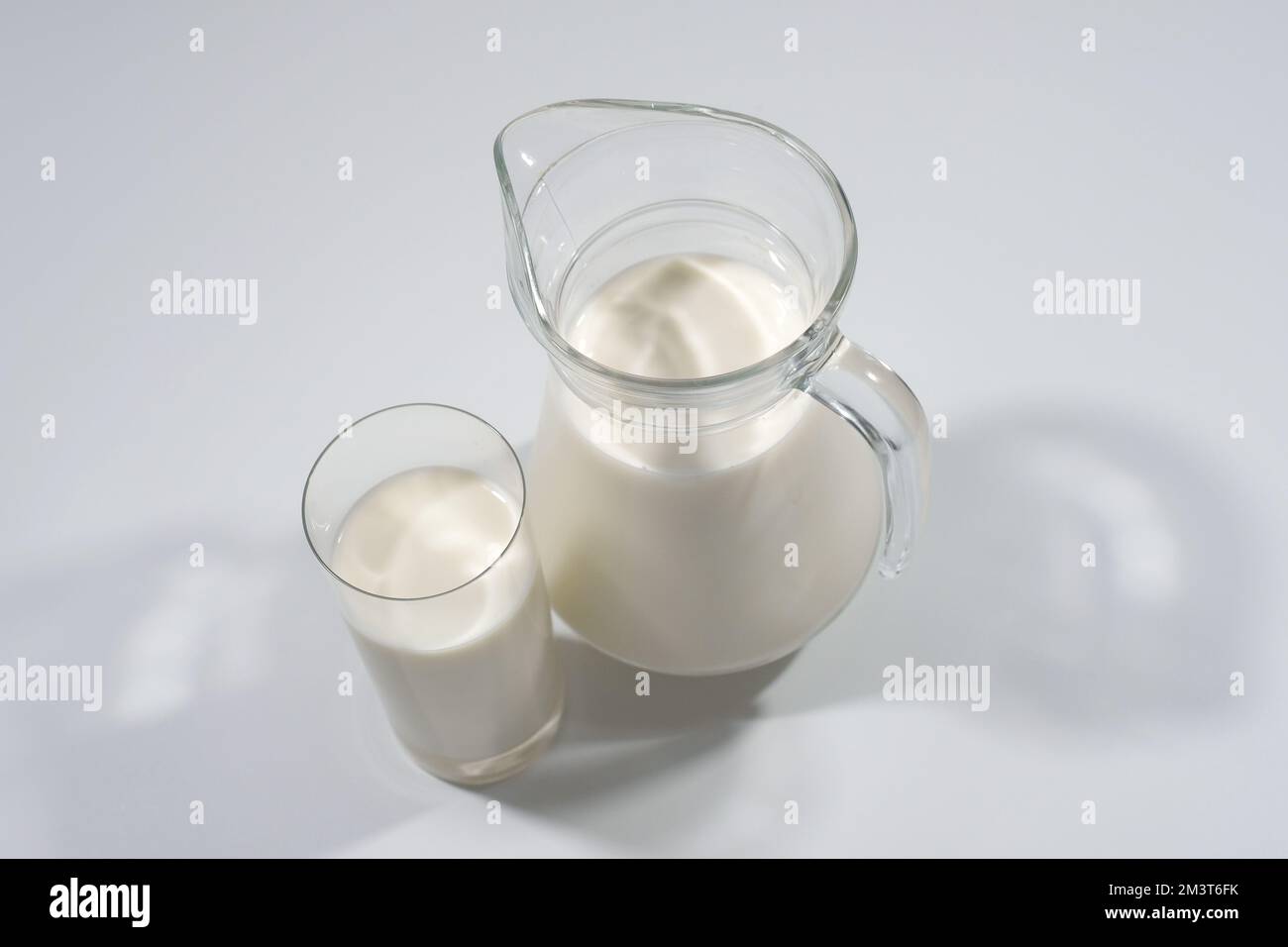 Milk in a glass with a jug on a gray background. Side view. Milk ...