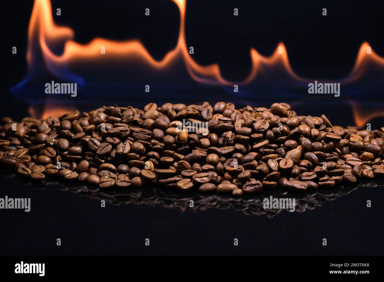 Coffee on fire on a black background with reflection. Coffee roasted ...