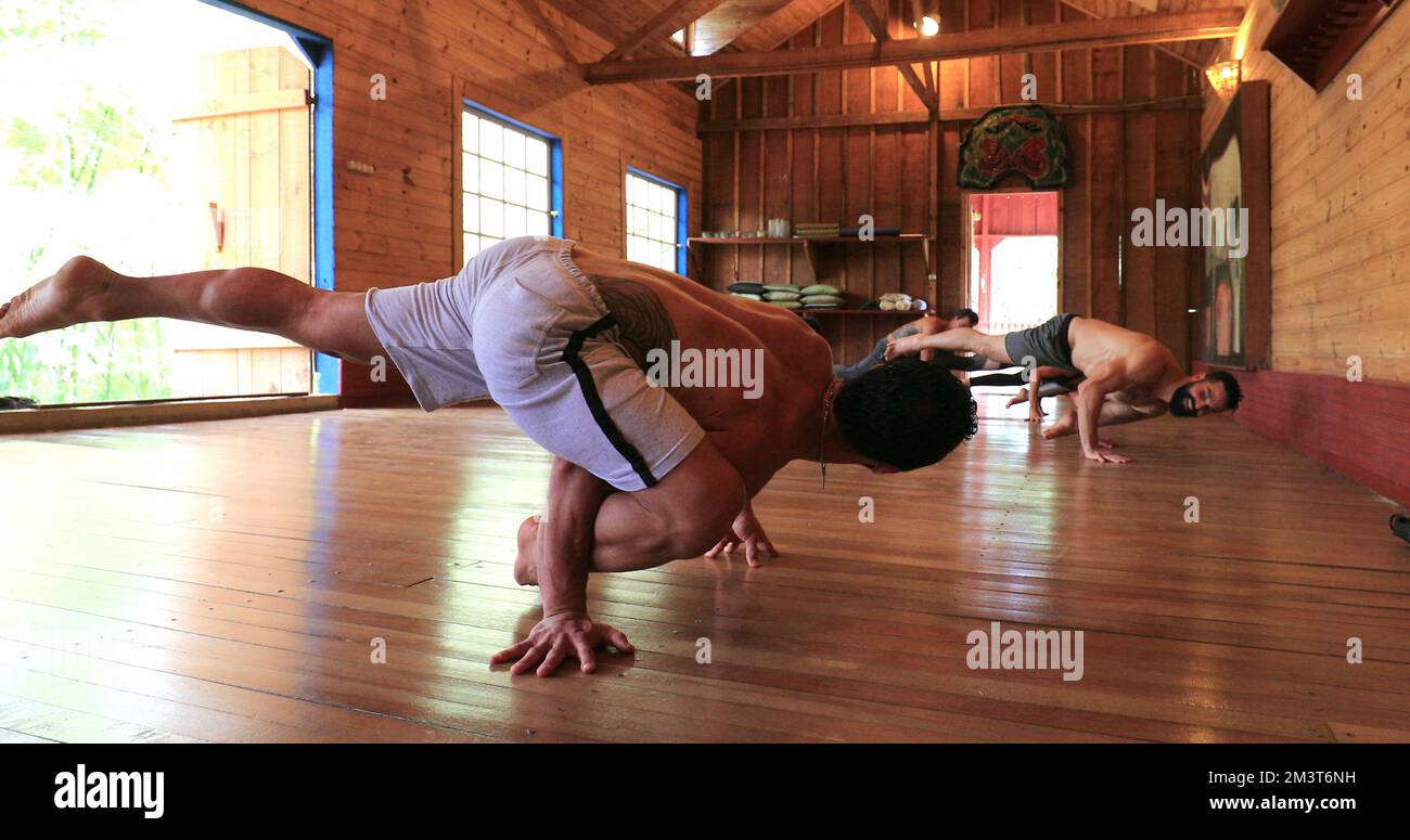 Yogi instructor teaching students advanced Yoga asana pose Stock Photo ...