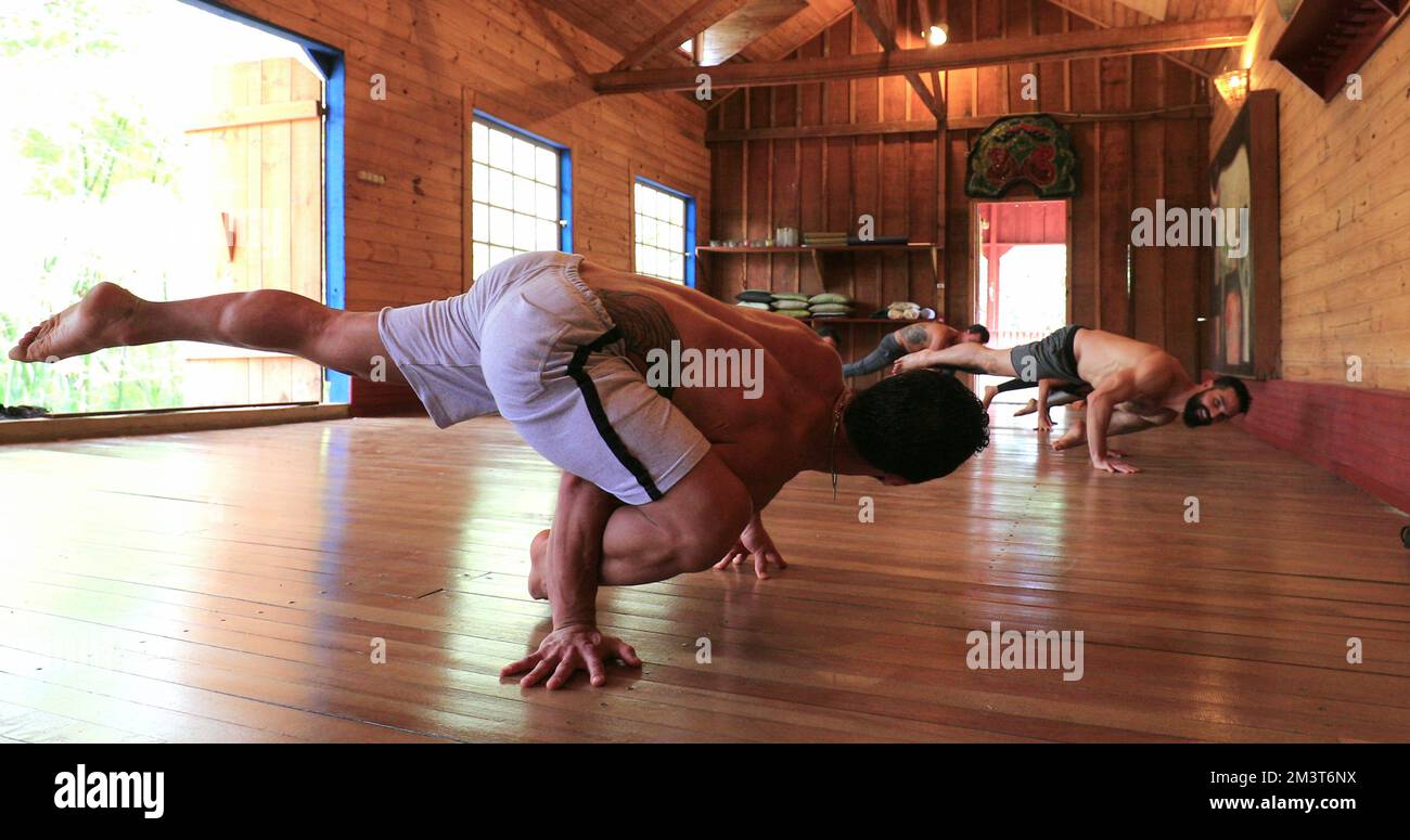 Yogi instructor teaching students advanced Yoga asana pose Stock Photo ...