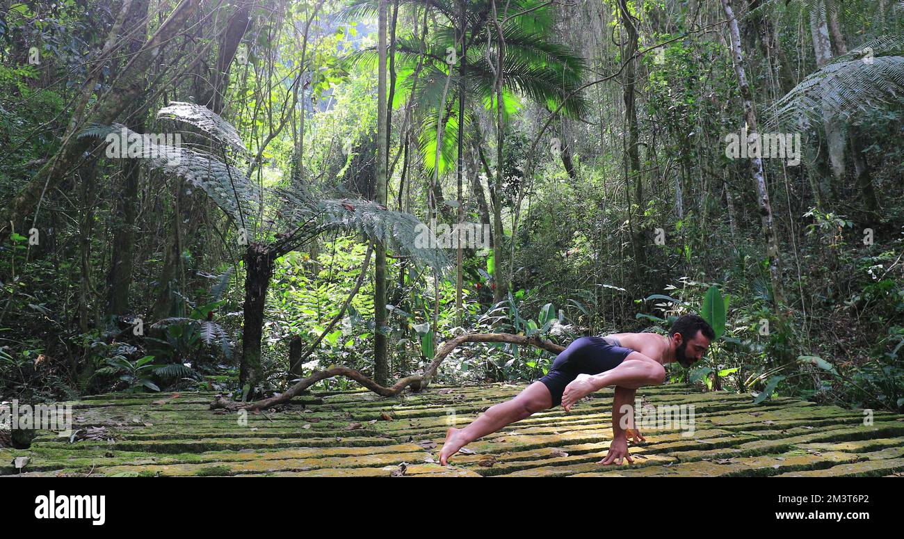Yogi man training Yoga in handstand pose in the middle of tropical ...