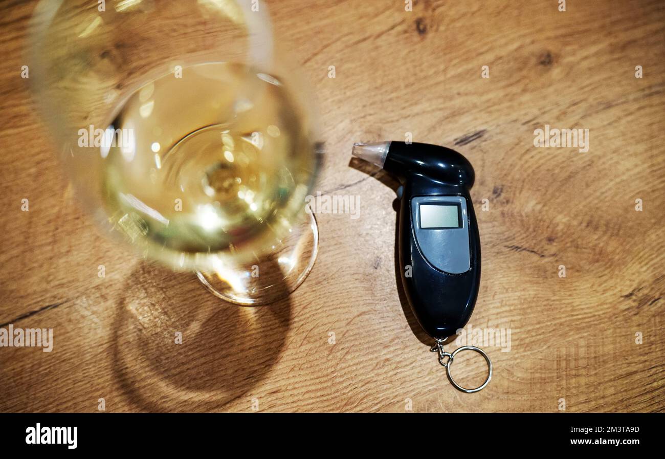 Portable breathalyzer and a glass of white wine Stock Photo - Alamy