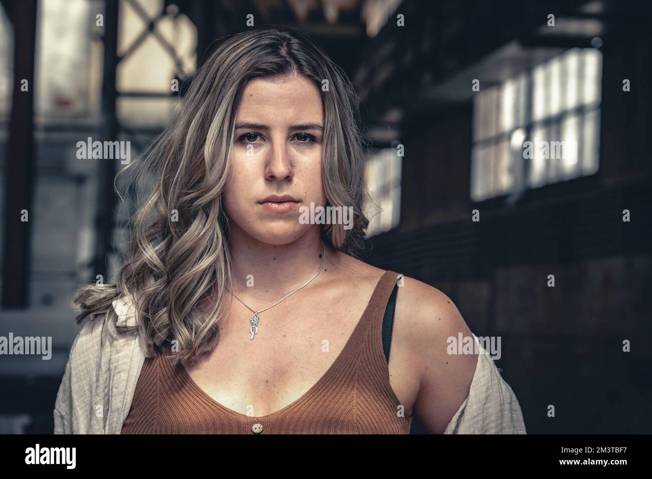 A closeup of a female standing indoors in an empty building and ...