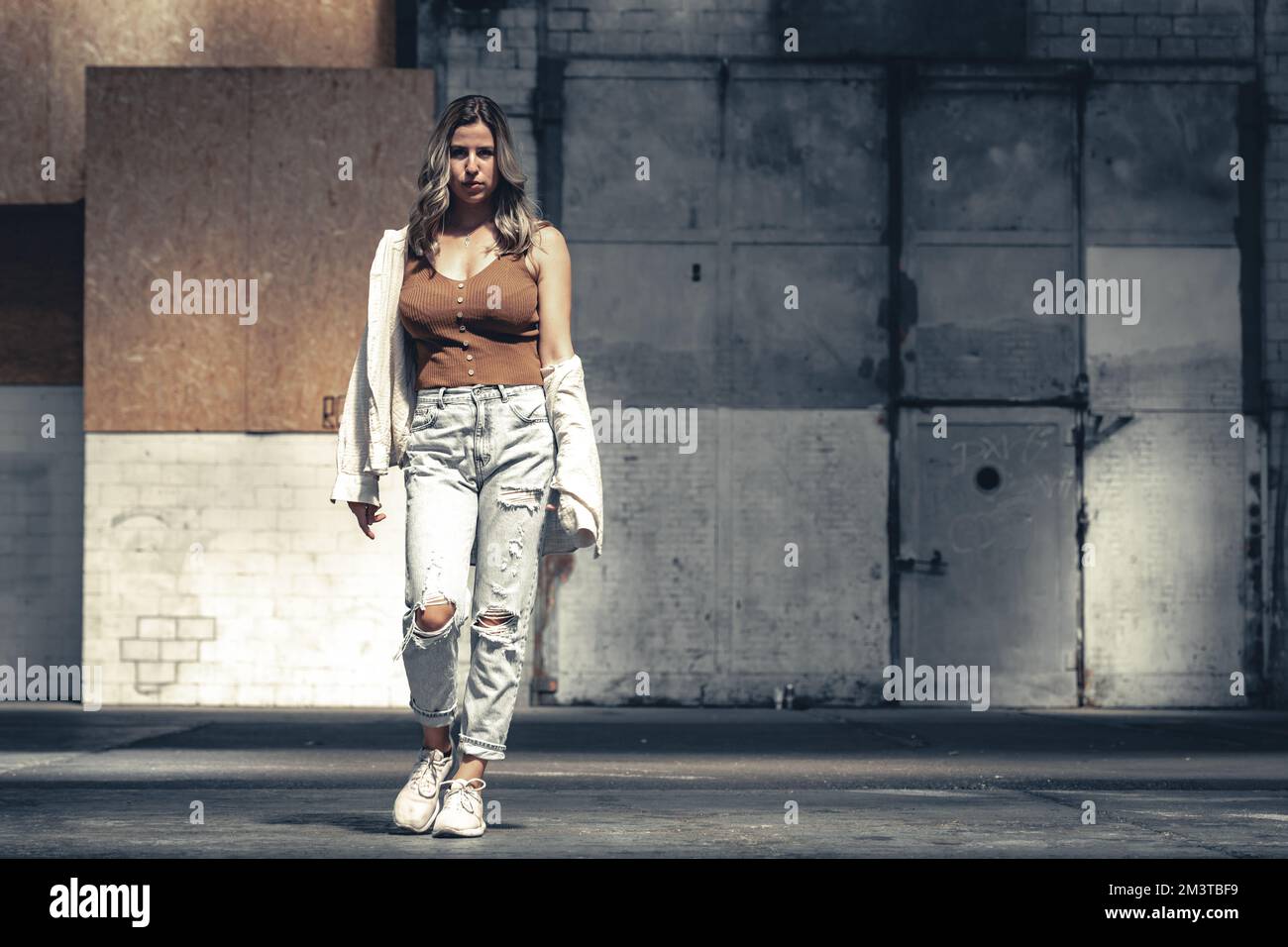A closeup of a female standing indoors in an empty building and ...