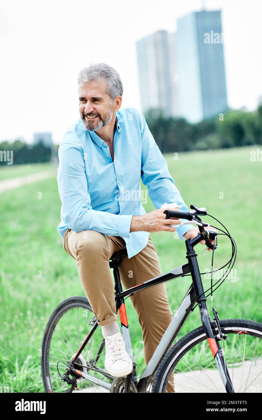 senior man smartphone bicycle cycling cell mobile phone outdoor city ...