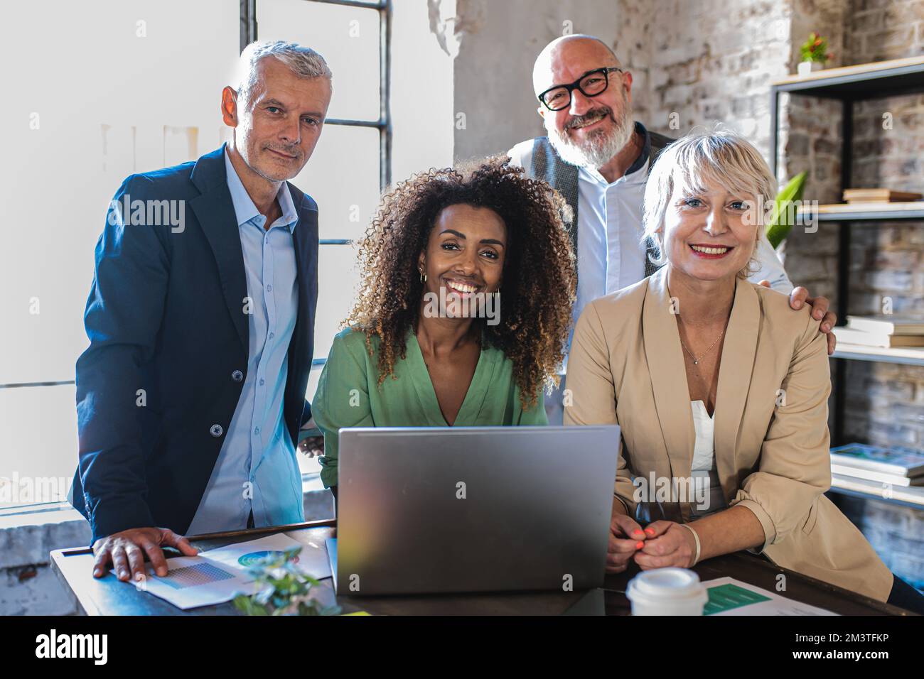 Portrait of a smiling group of diverse colleagues standing together at ...