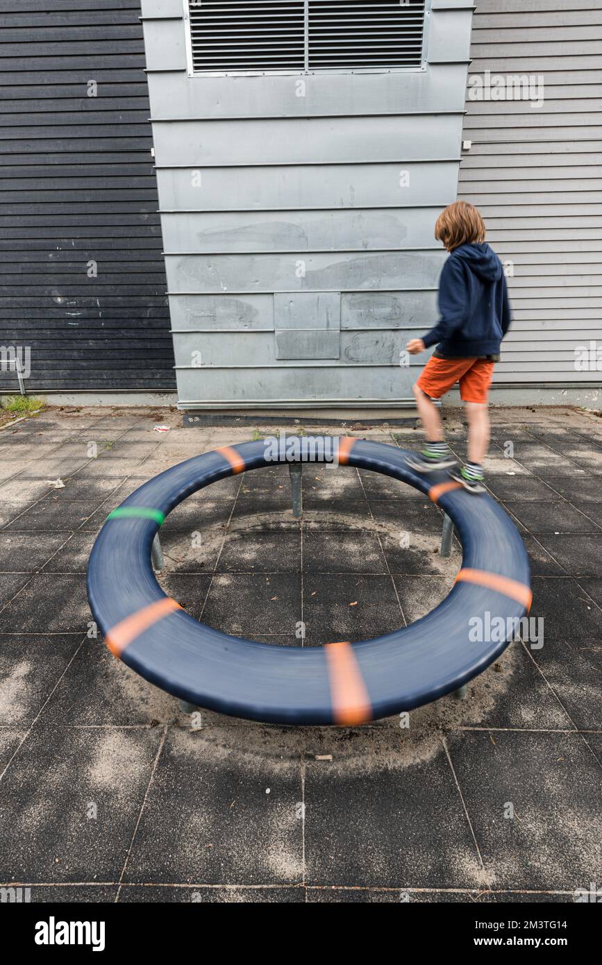 Lindesnes, Norway - July 19 2016: Kid running on a spinning wheel at a ...