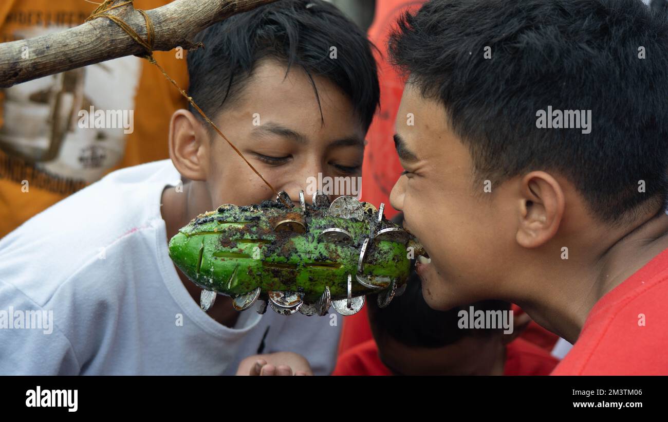 Two young men doing bite a coin competition on Indonesian Independence ...