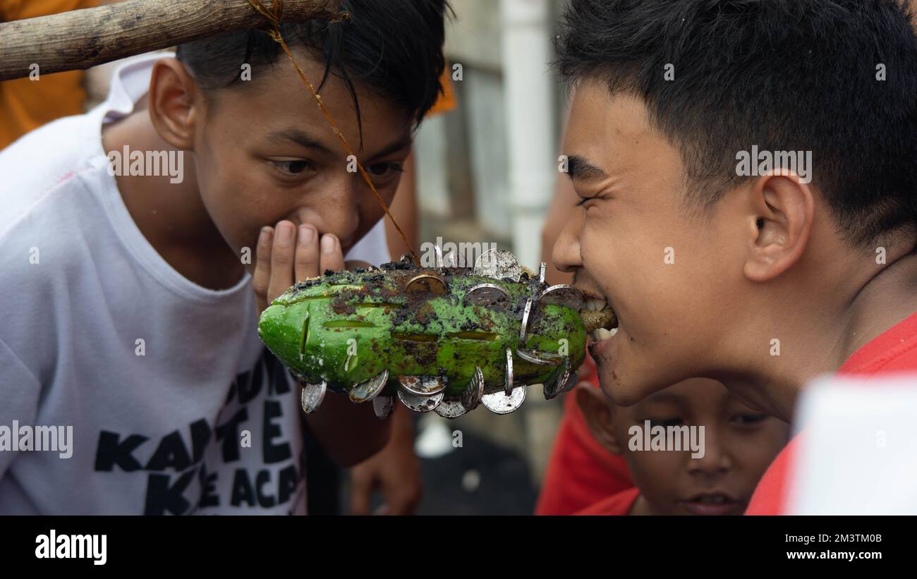 Two young men doing bite a coin competition on Indonesian Independence ...
