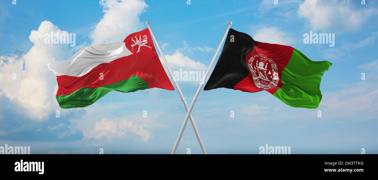two crossed flags Afghanistan and Oman waving in wind at cloudy sky. Concept of relationship ...