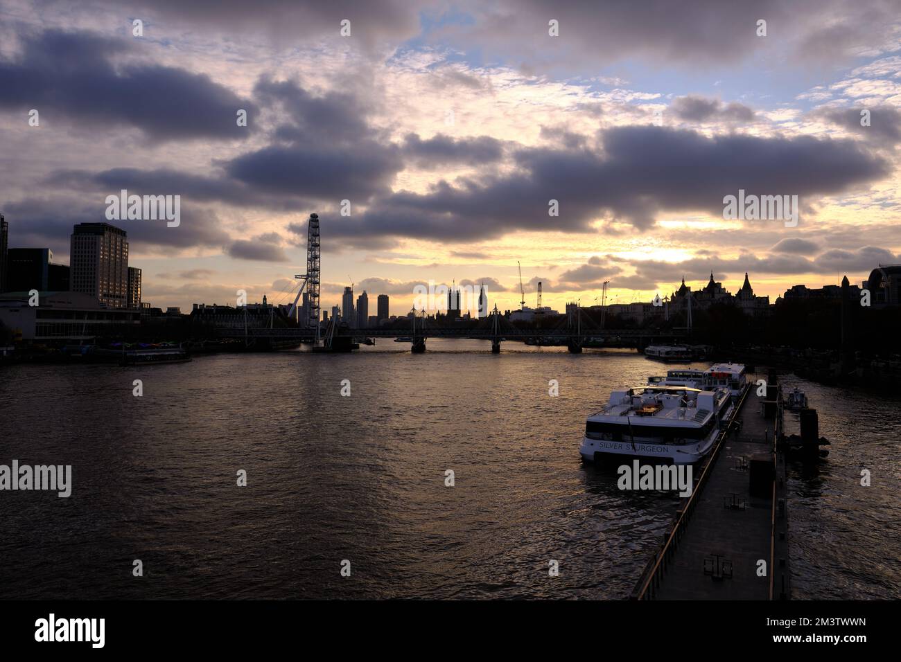 View of the Thames River at sunset. Silhouette of landmarks such as ...