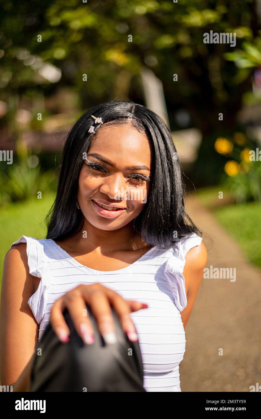 Young attractiv woman sitting on a ledge by the side of a street, with ...