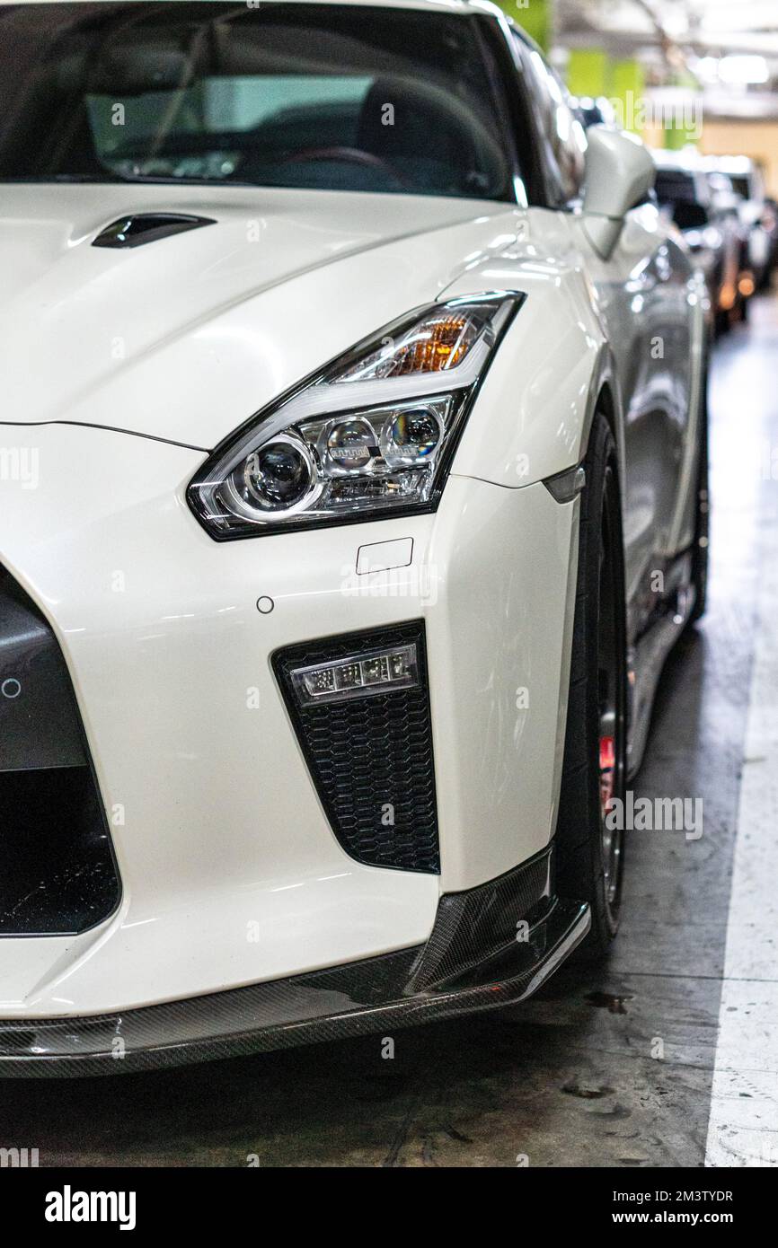 A vertical shot of a white Nissan GT-R sportscar in a parking lot Stock ...