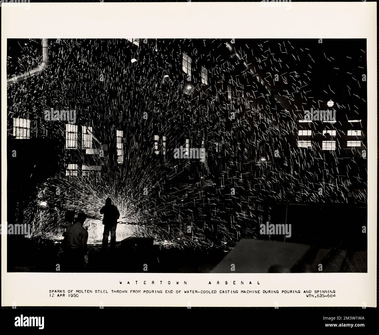 Sparks of molten steel thrown from pouring end of water-cooled casting ...