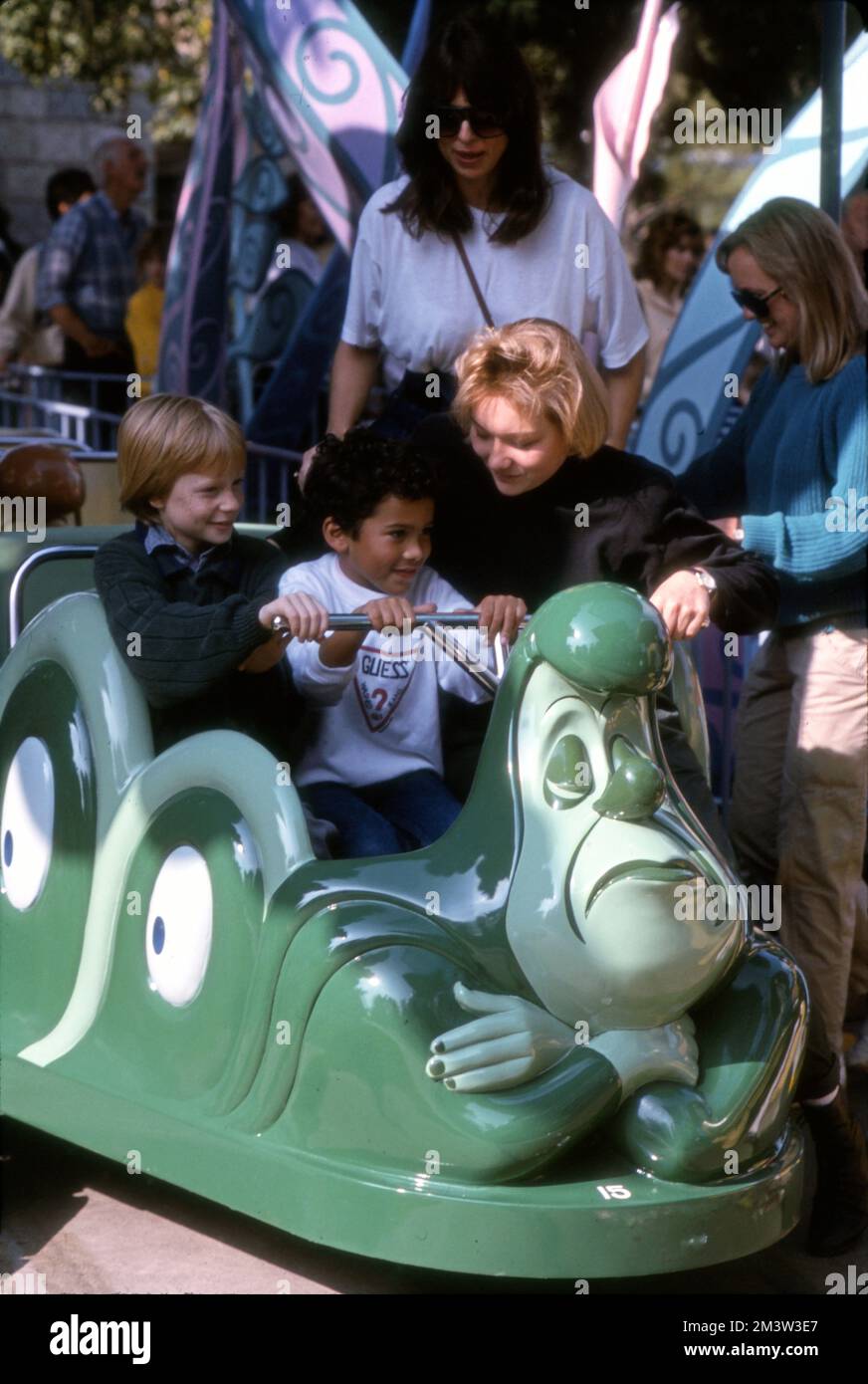 Visitors to Disneyland in a car for the Alice in Wonderland ride ...