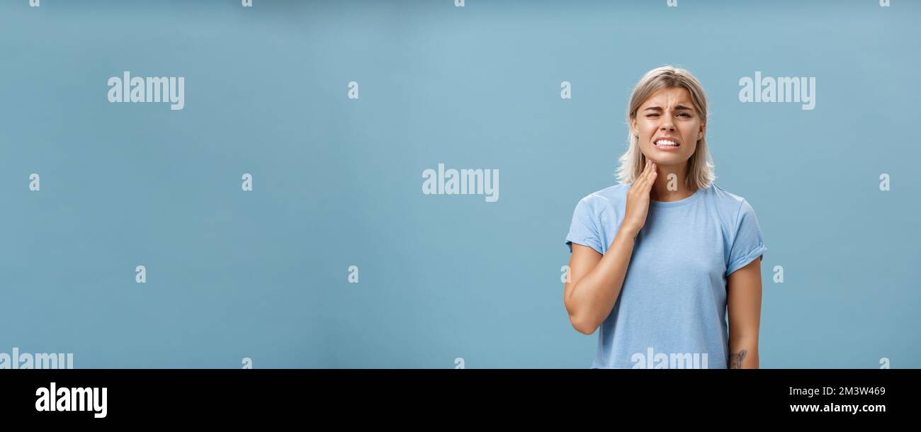 Ouch my throat. Displeased unhappy good-looking adult blonde girl with ...