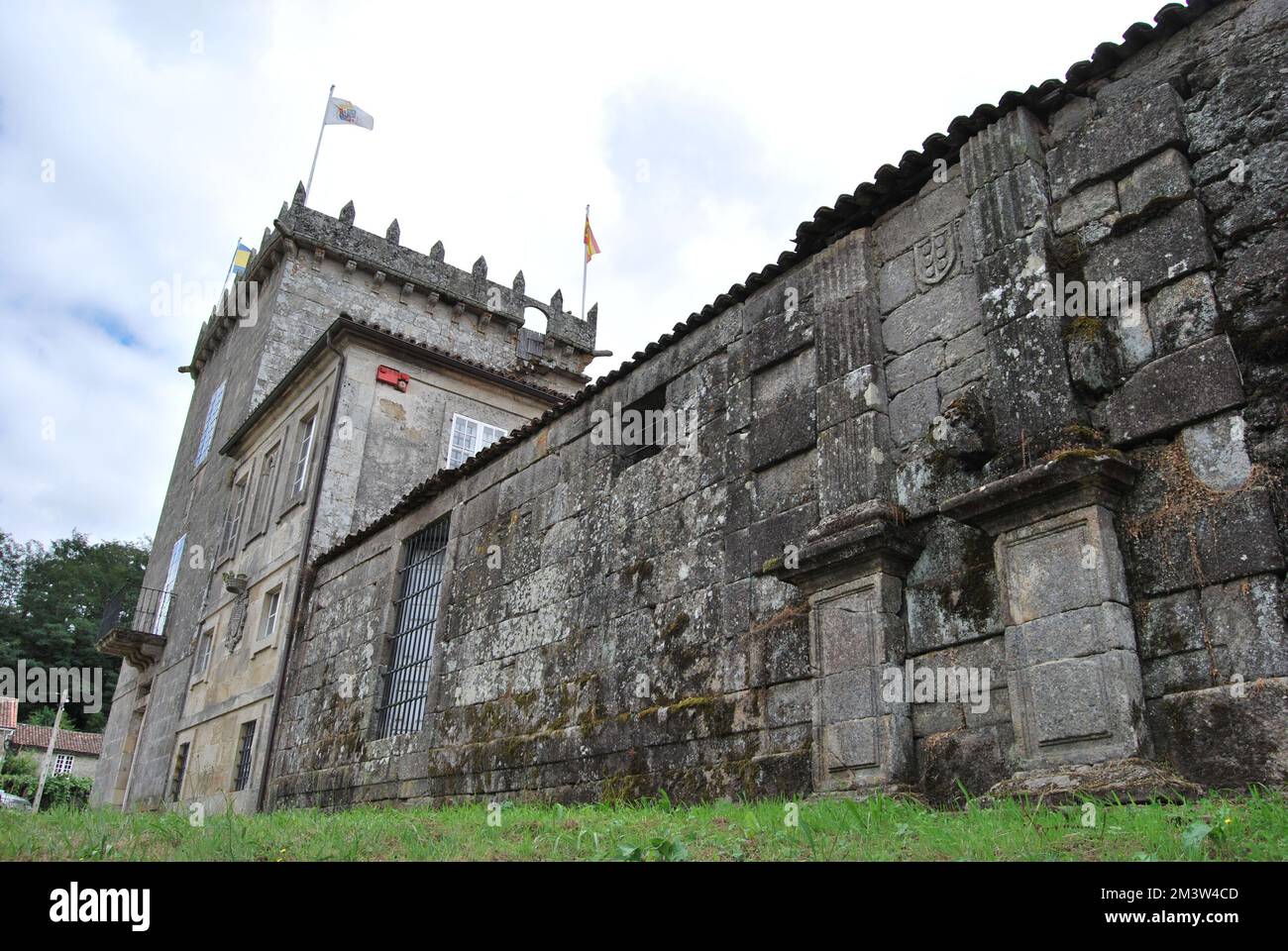 The exterior of an old architecture with flags on the top in the ...