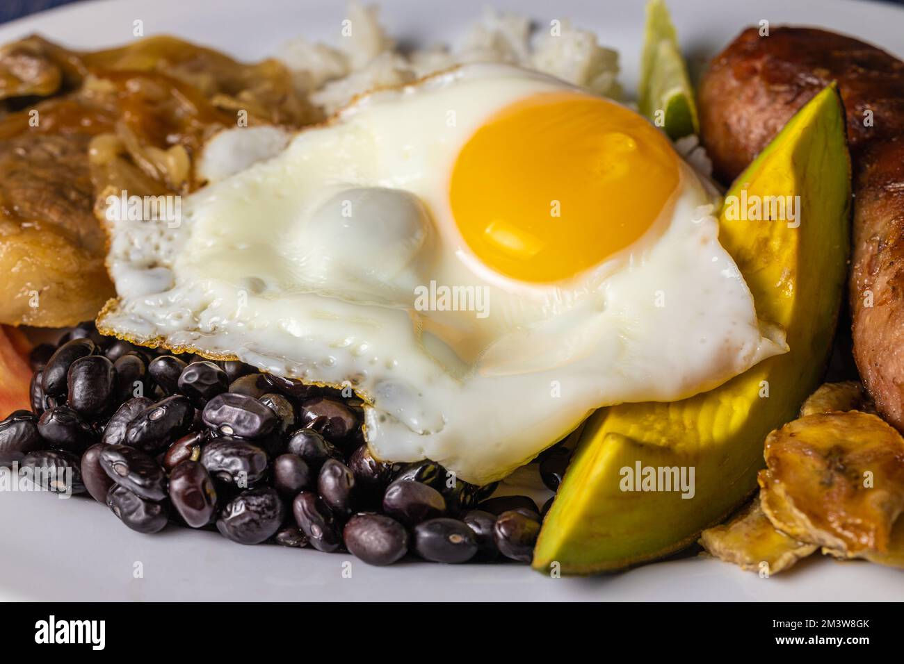 Close up of Bandeja paisa, typical food of Colombia with egg, beans and ...