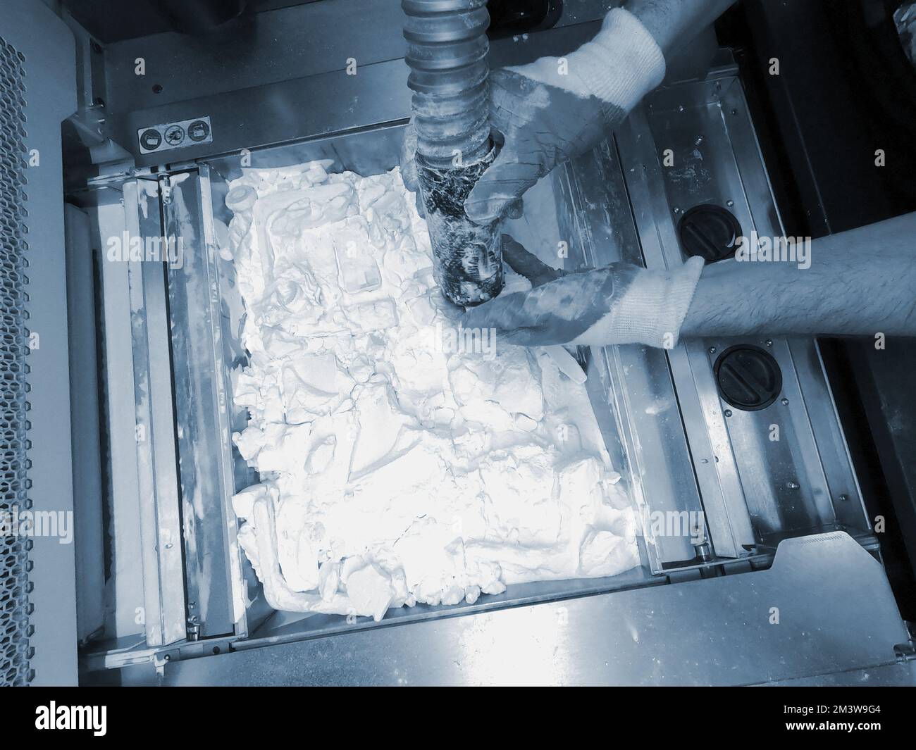 Mane taking out models from white polyamide powder in working chamber ...