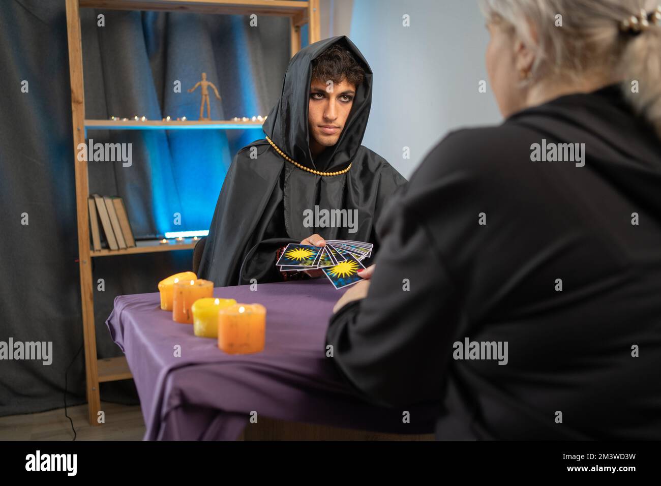 Male sorcerer reading tarot cards, divination concept Stock Photo - Alamy