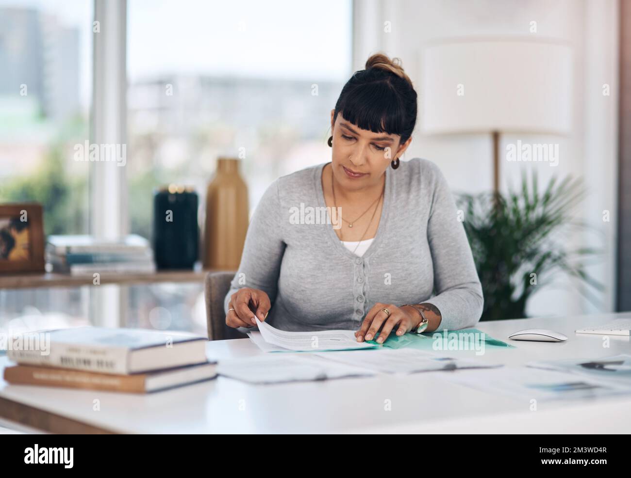Updating the files. an attractive young businesswoman sitting alone in ...