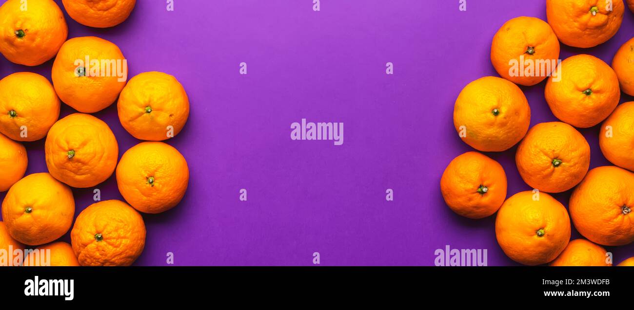 Ripe bright orange tangerines on lilac background, fruit banner. Top ...