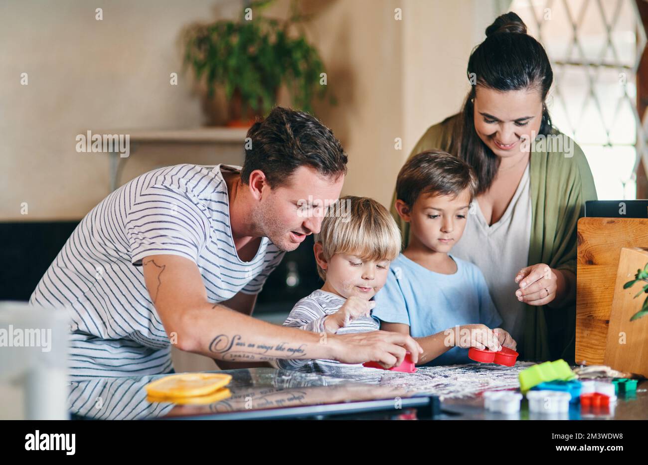Home is what you bake of it. a young family of four baking at home ...