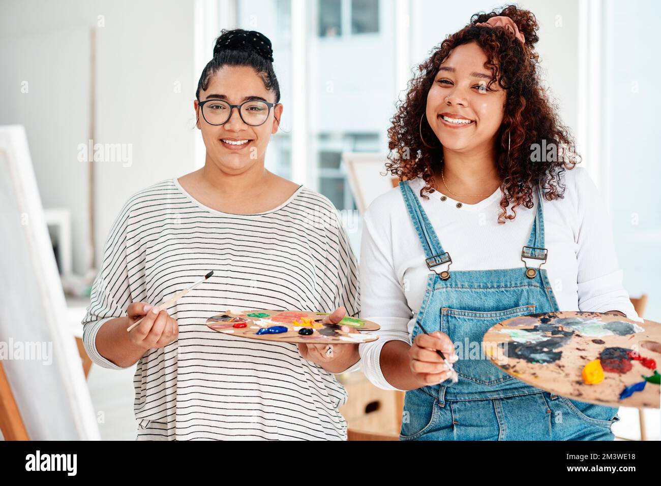 We bond through art classes. Cropped portrait of two attractive artists ...