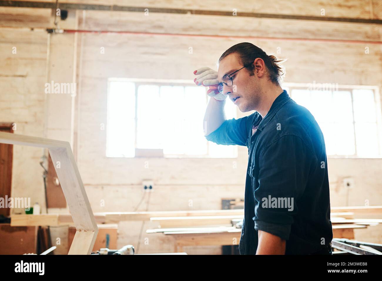 You work up quite a sweat down here. a handsome young carpenter wiping ...