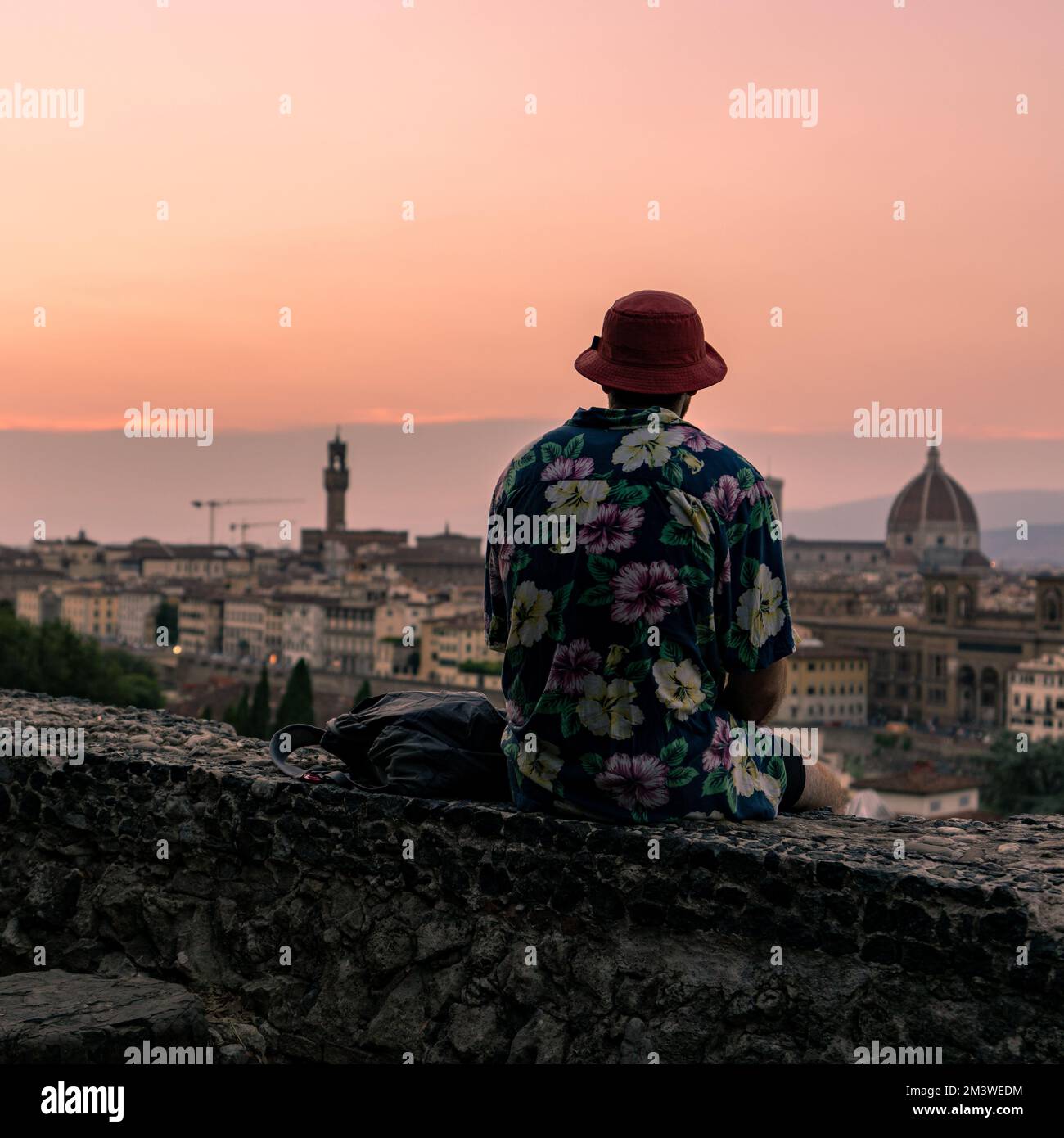 A back view of a male street artist looking at Florence, Italy at ...