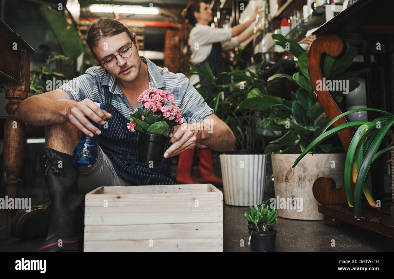 Just making sure every flower gets enough water. a handsome young ...