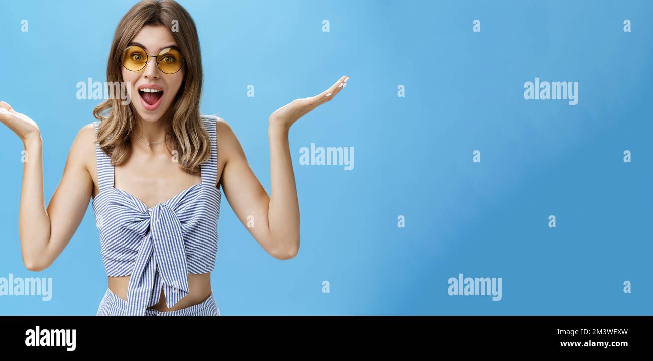 Waist-up shot of charismatic cute young woman in sunglasses raising ...
