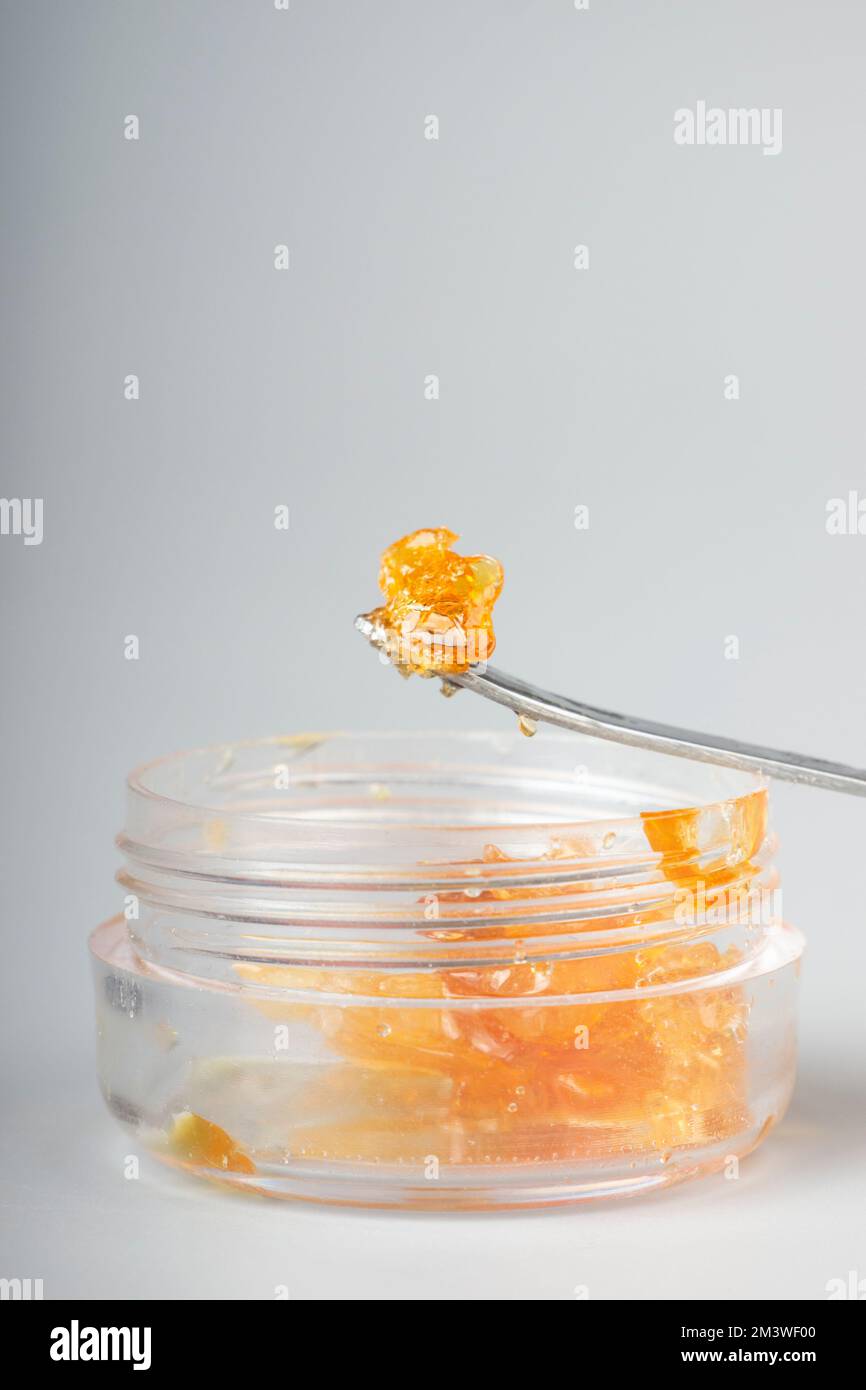 high thc smoking cannabis golden wax glass box closeup and dab stick ...