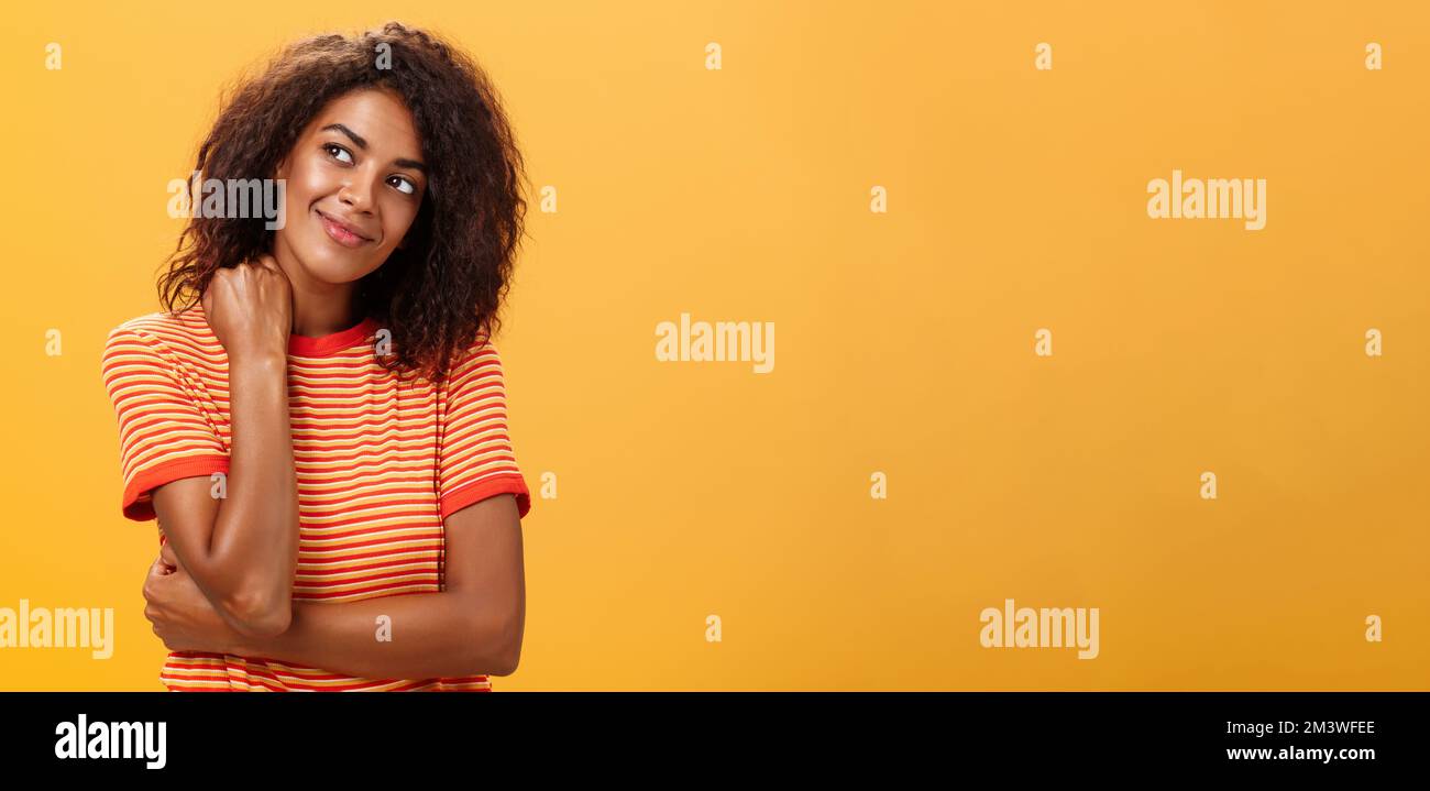 Cute and gentle dreamy dark-skinned girl with cruly hairstyle tilting ...