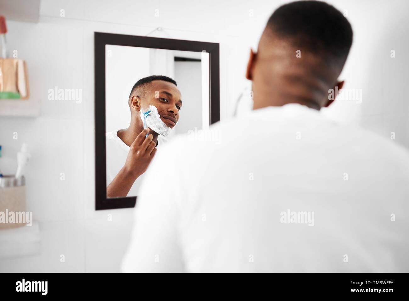 I like the clean look. a young man applying shaving foam to his face Stock Photo - Alamy