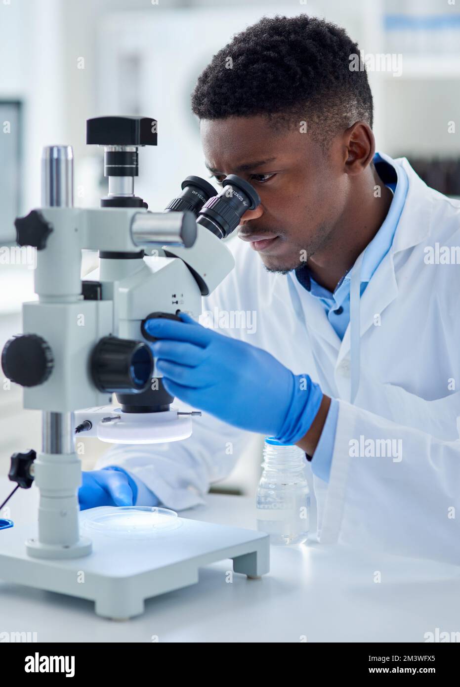 Taking a closer look. a focused young male scientist looking at test ...