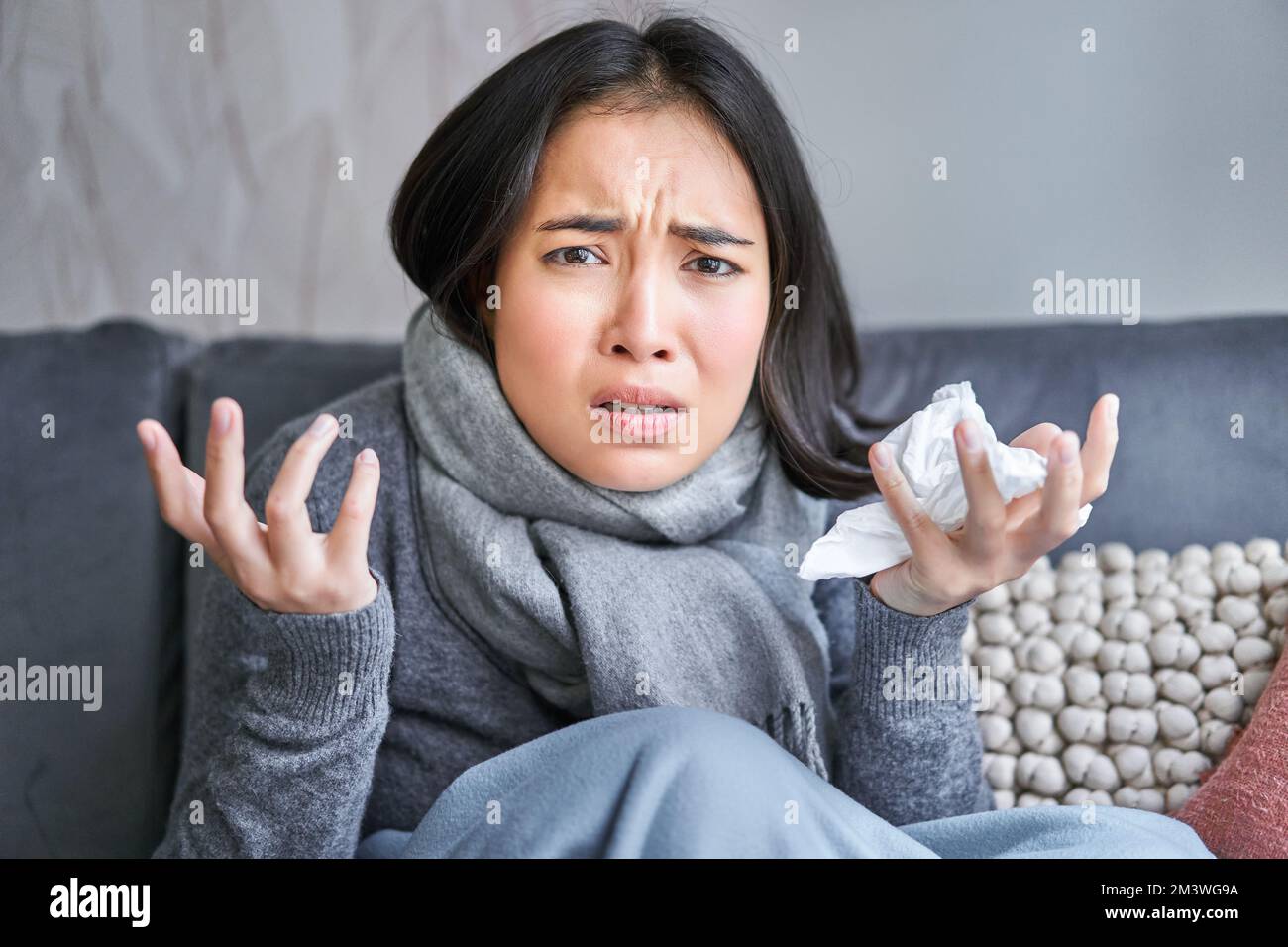 Portrait of sad woman feeling unwell, wearing warm clothes and scarf at ...
