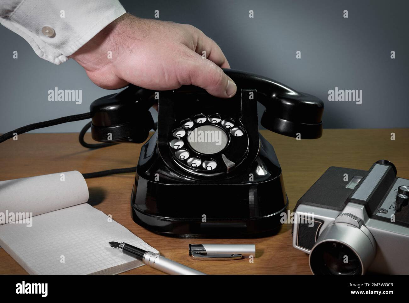 The hand reaches for the phone. Old telephone set on a wooden table ...