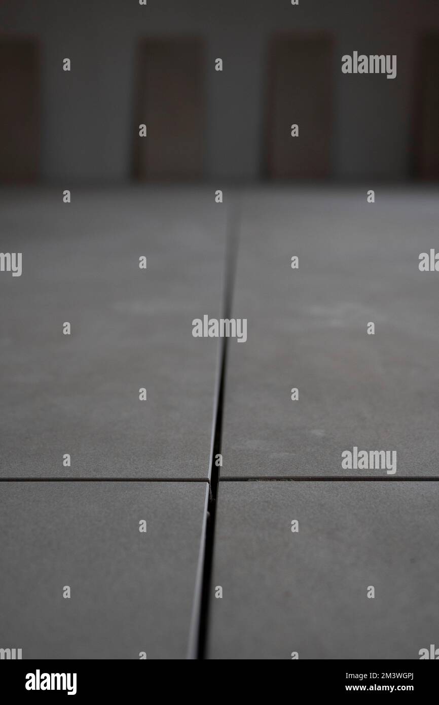 A vertical partial view of the new gray tiled floor - tile installation ...