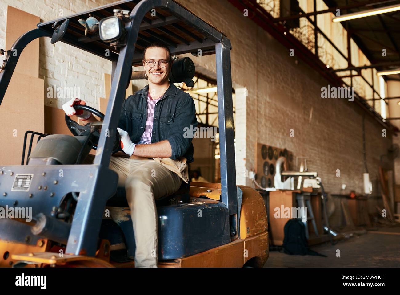 Lets get things moving. a young male warehouse worker driving a ...