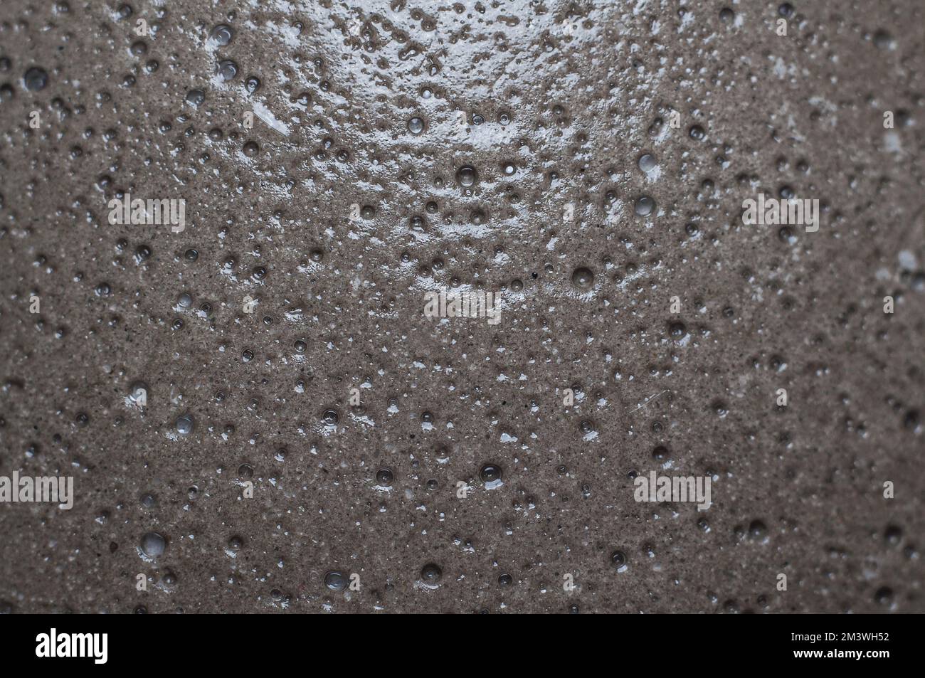 Concrete surface with voids and bubbles, covered with varnish. Building ...