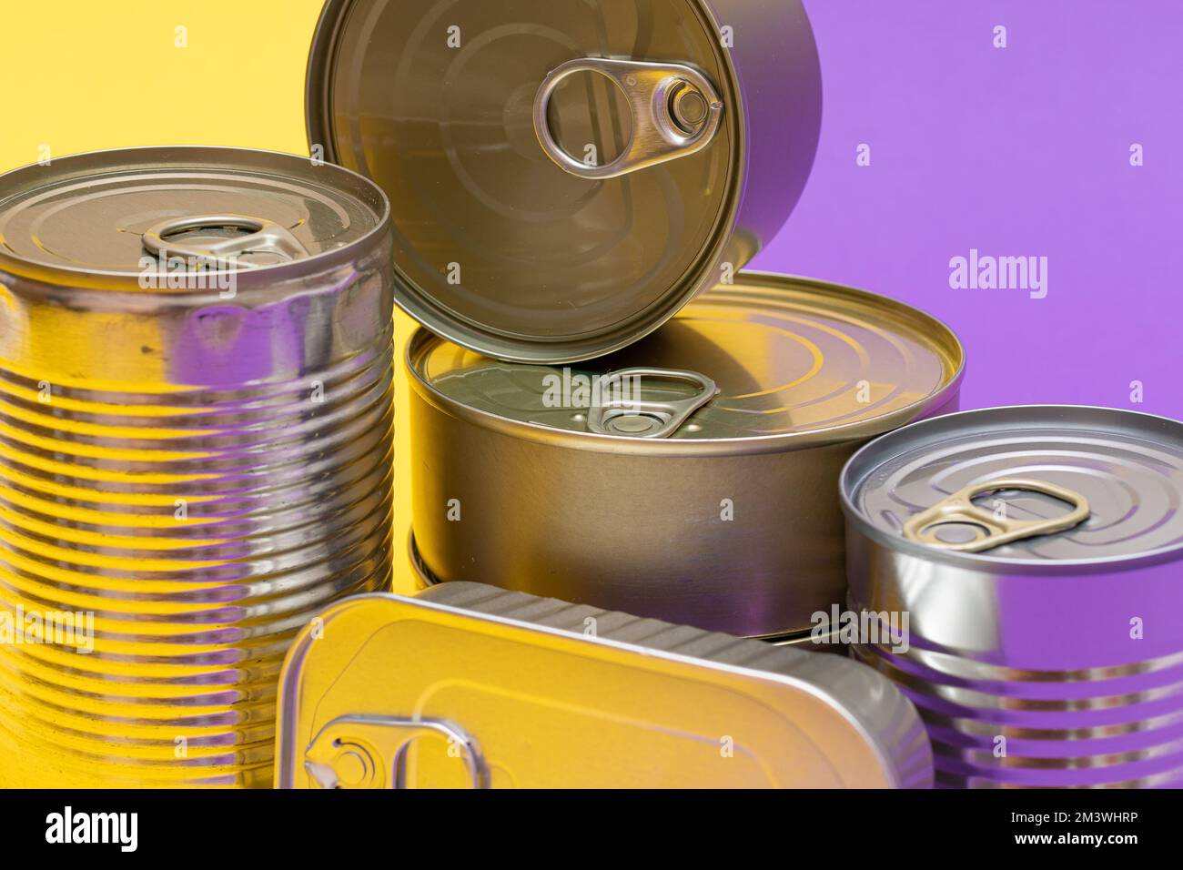 A Group of Stacked Tin Cans with Blank Edges on Split Yellow and Violet ...