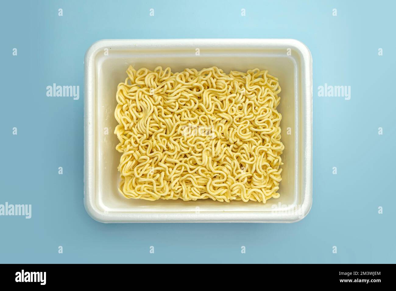 Dried Instant Noodles in Plastic Box on the blue table. top view Stock ...