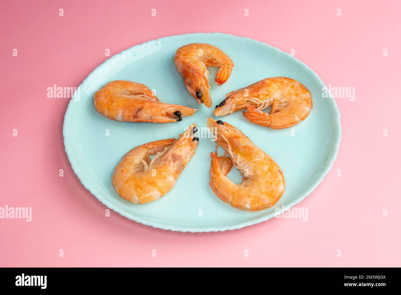 boiled shrimp in a plue plate on a pink background Stock Photo - Alamy